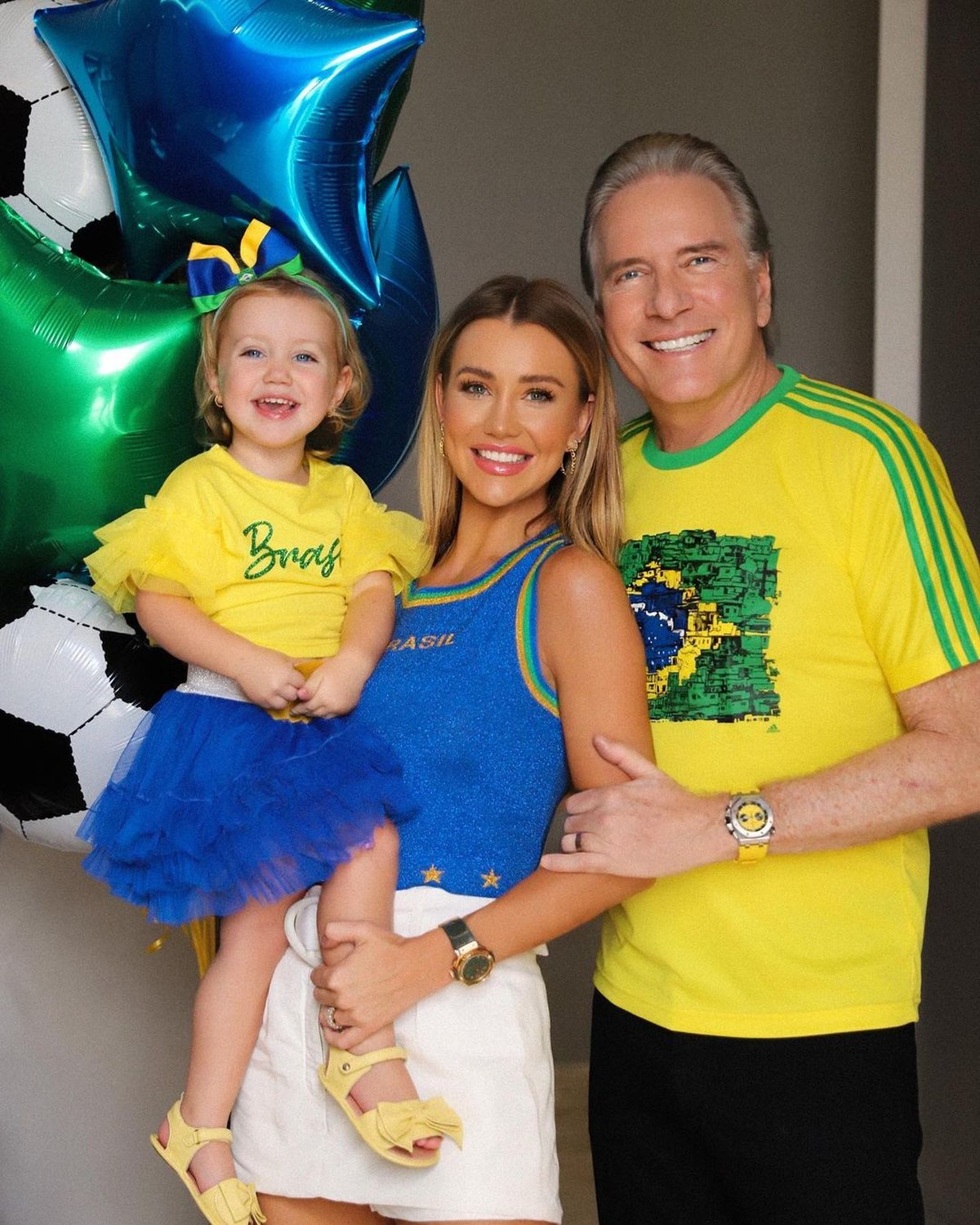 Ao lado de mulher e filha, Justus posa sorridente ao torcer para o Brasil